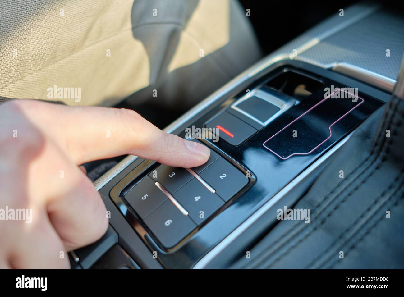 A man in a modern car. Hand presses the buttons with numbers. Close up ...