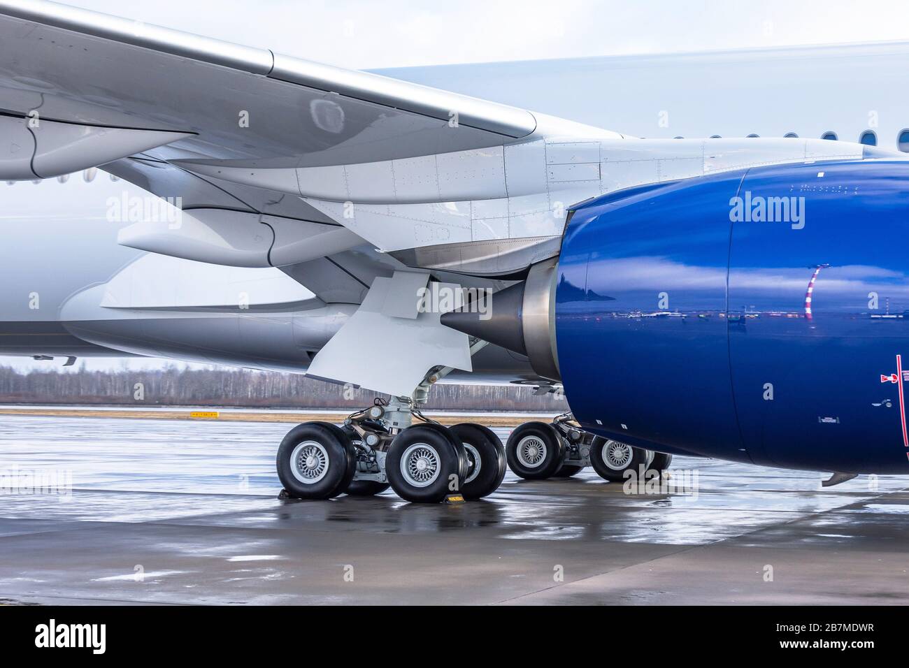 Airplane side view at the airport showing landing gear, under wing and ...