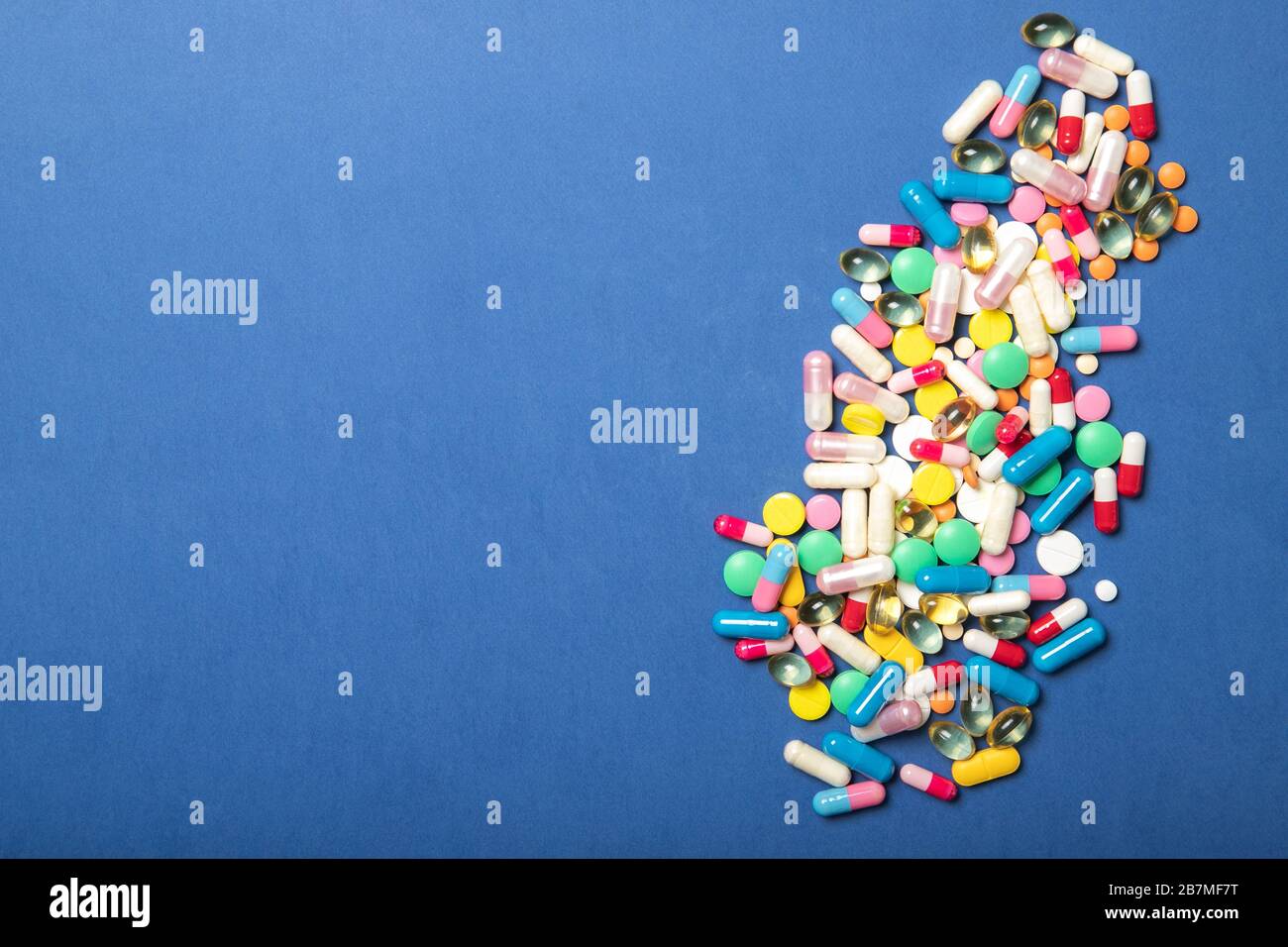 Multi-colored pills on a blue background with place for text Stock ...