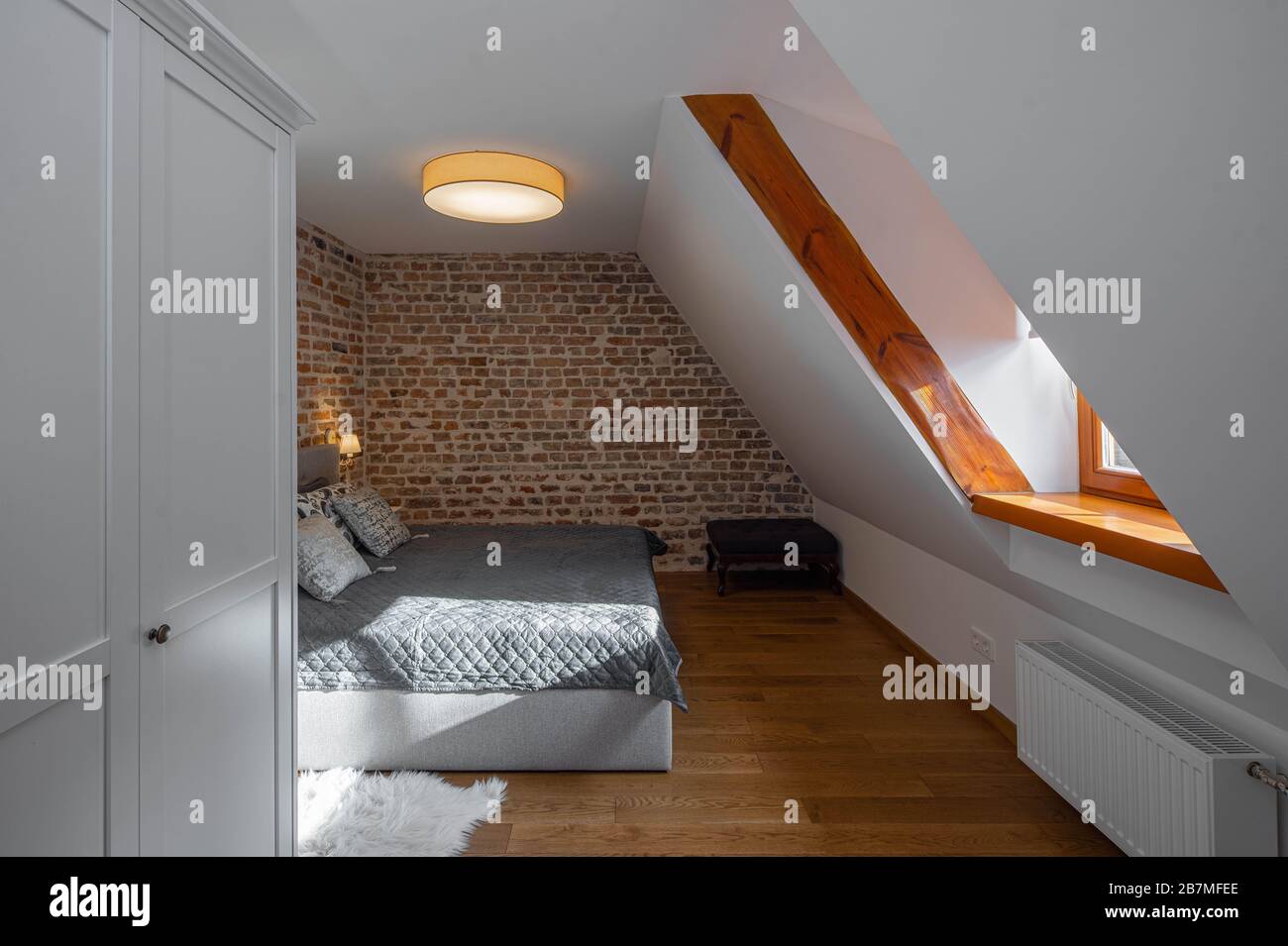 Modern loft interior of luxury bedroom. The sloping ceiling with window ...