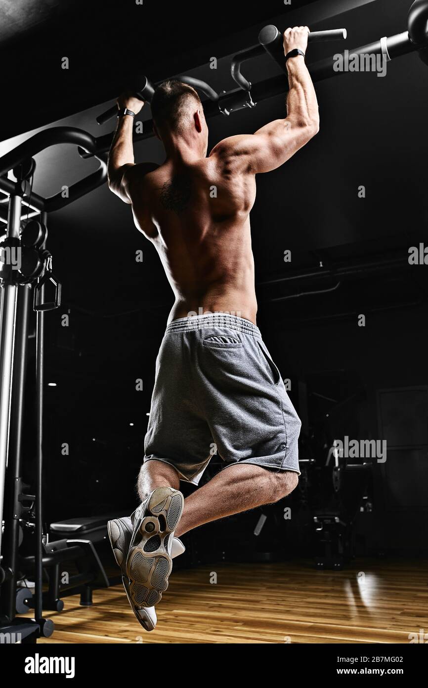 Strong man doing pull-ups on a bar in a gym Stock Photo - Alamy