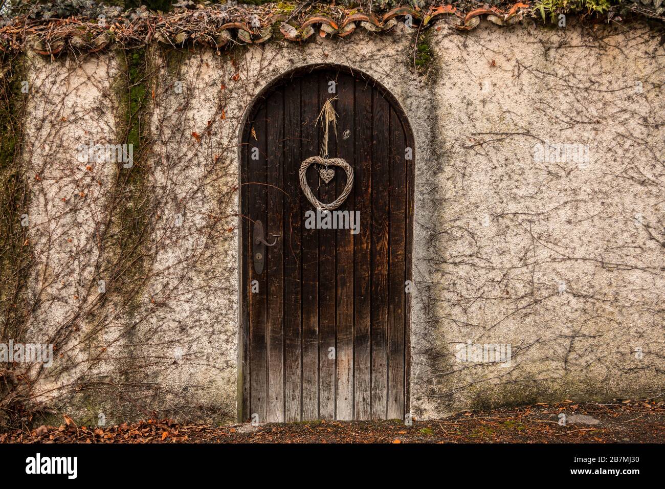 Old wooden door in a long stone wall Stock Photo - Alamy