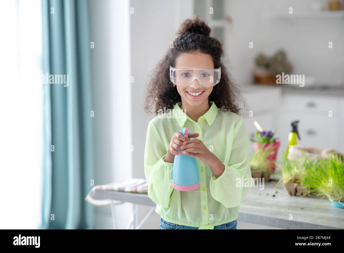 Girl in goggles with a water spraying in her hands Stock Photo - Alamy