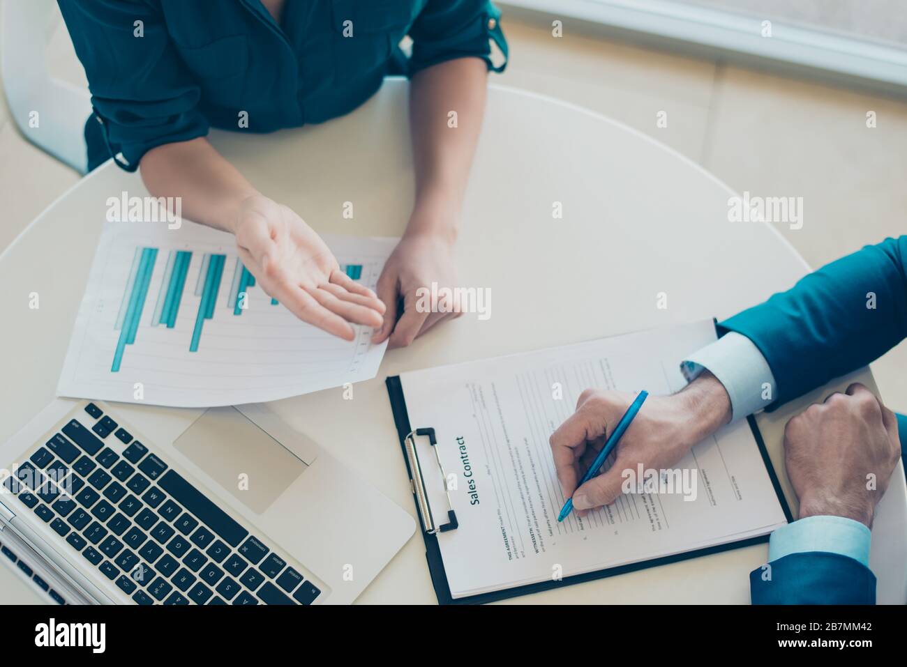 Close up photo of man signing sales contract and woman telling him ...