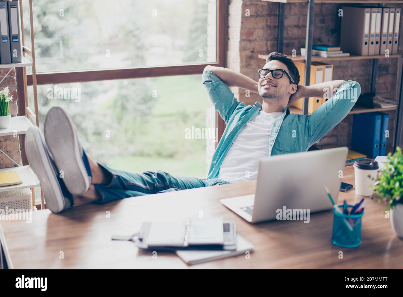 Happy calm smiling man having a rest after solving all the tasks at ...