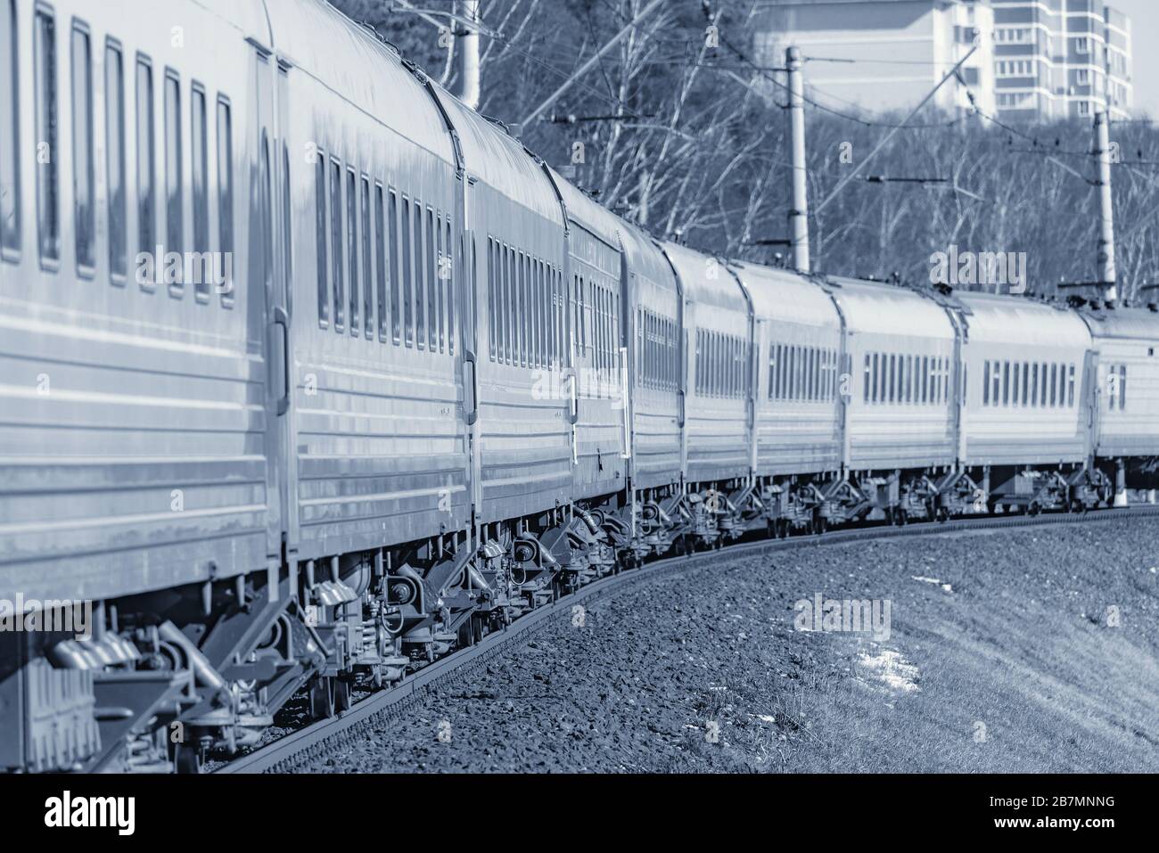 Passenger train approaches to the station at spring day time Stock ...