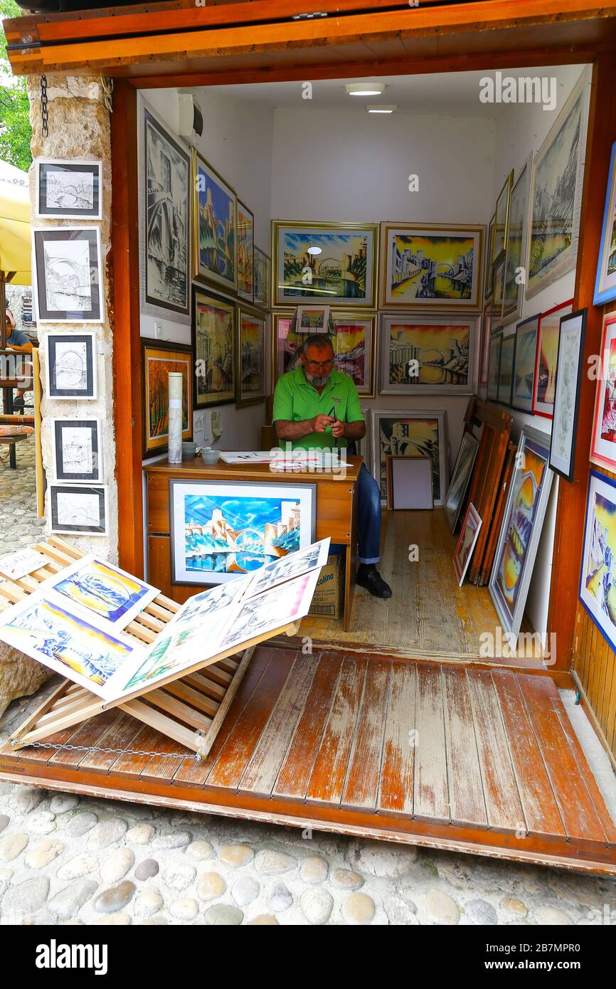 A artist in his studio selling paintings of the Old Bridge at Mostar ...