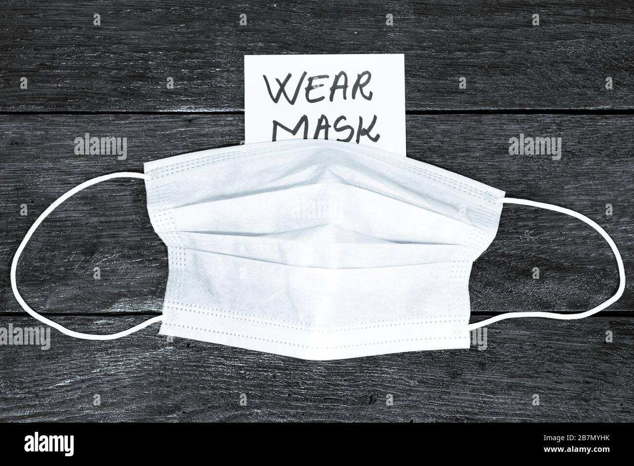 Writing wear mask on memo post reminder and surgical mask on wooden ...