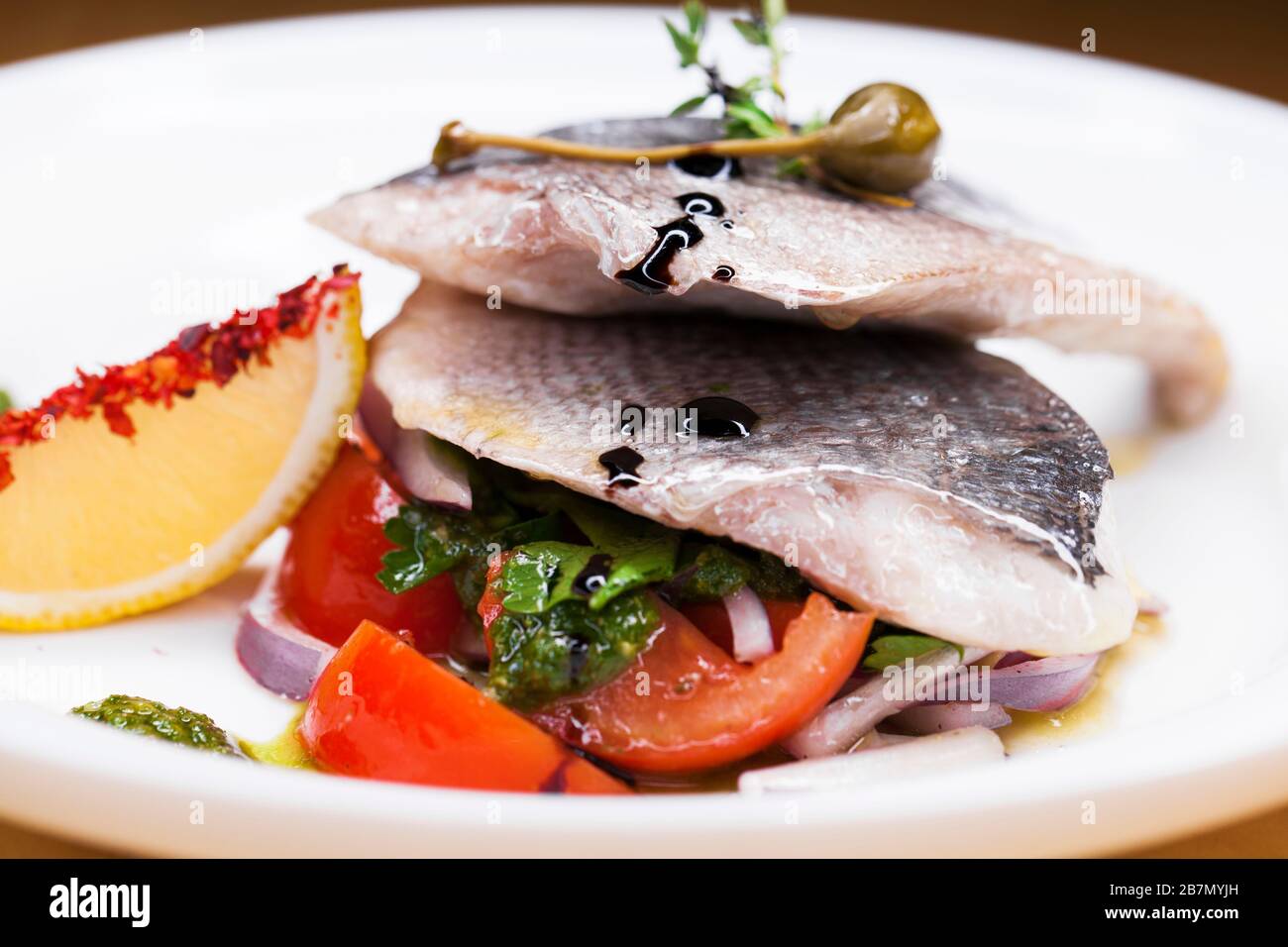 Restaurant food - Grilled Dorado fish with onion and lemon slice on ...