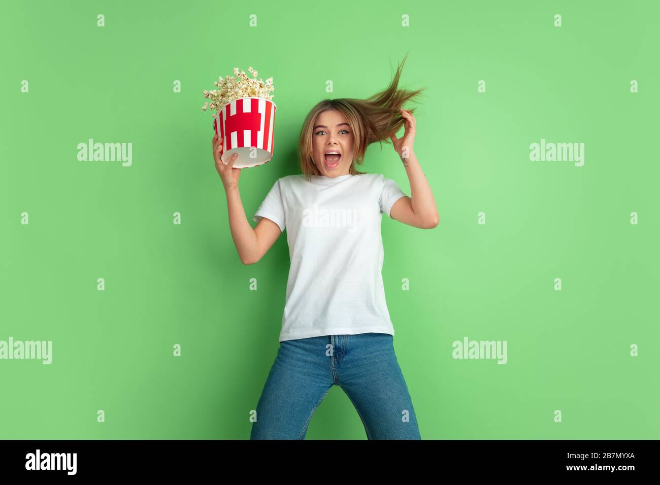 Screaming, popcorn's flying. Caucasian young woman's portrait isolated ...