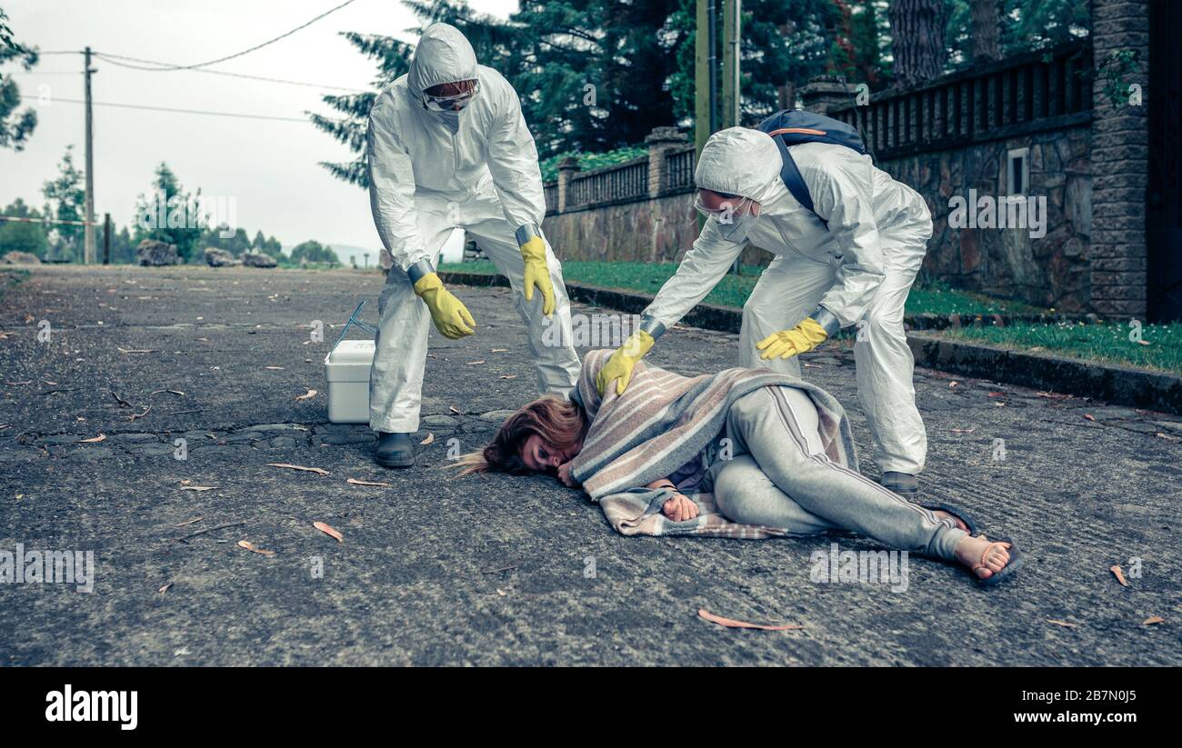 Doctors in protection suits caring for a woman Stock Photo - Alamy