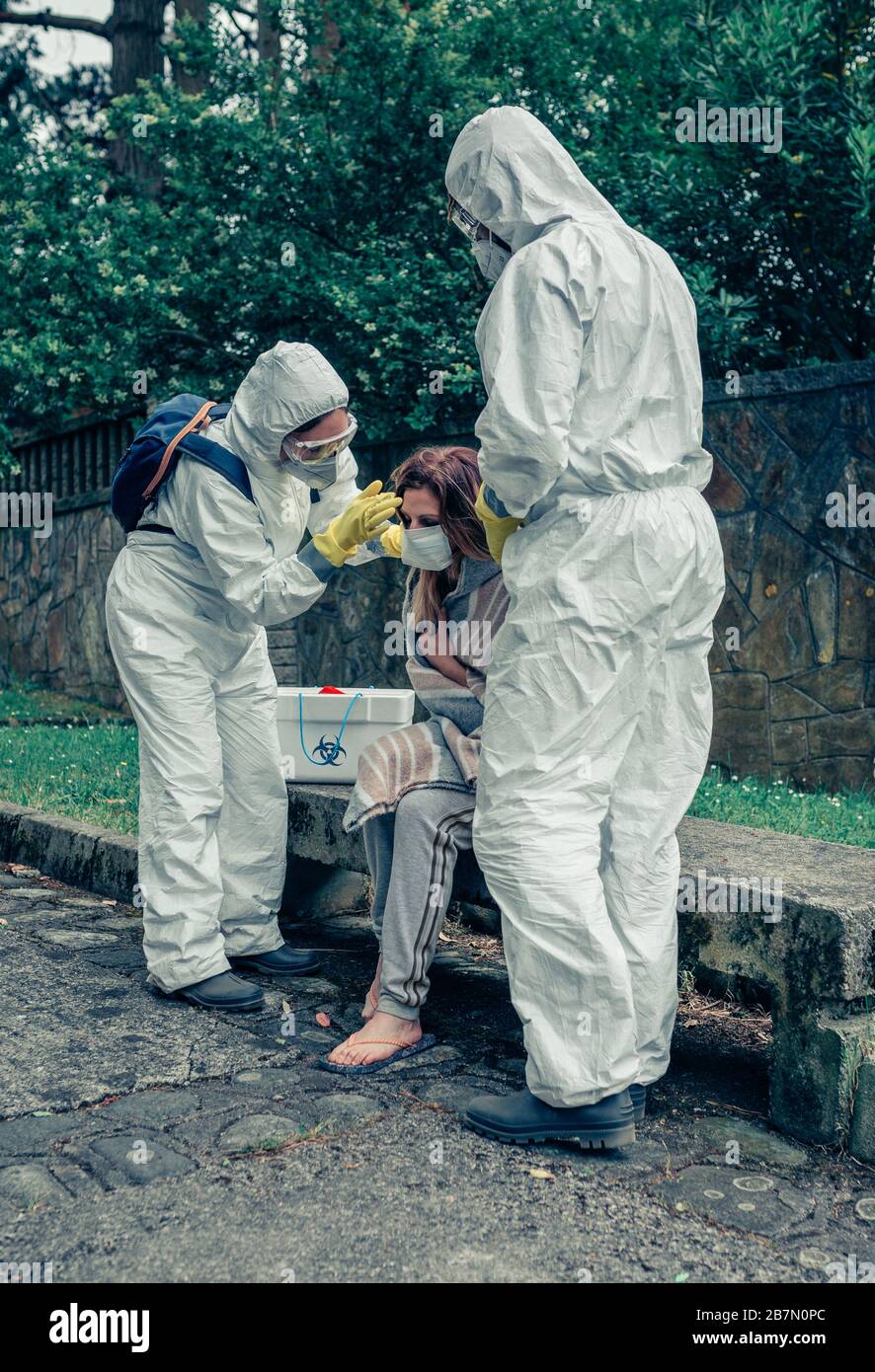 Doctors putting protective mask on woman infected with a virus Stock ...