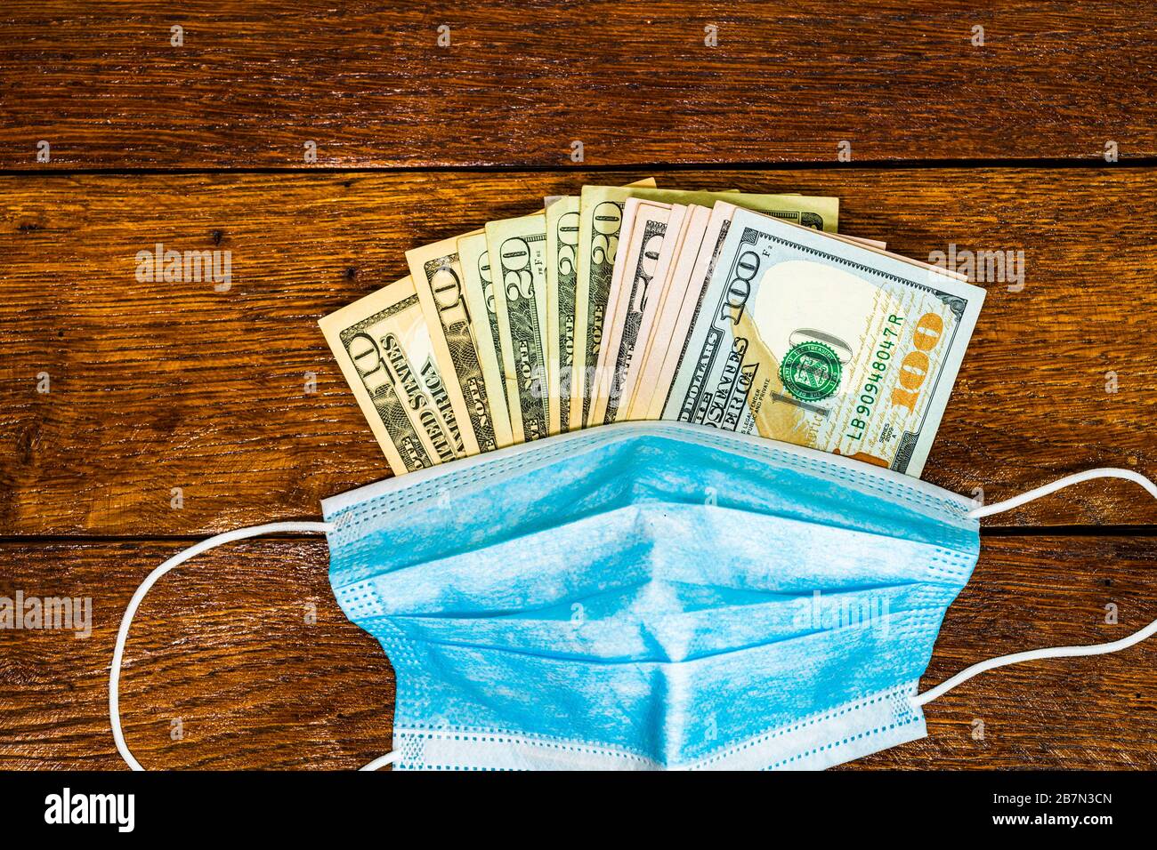 Money with surgical mask on wooden table. Flu disease virus spreading ...