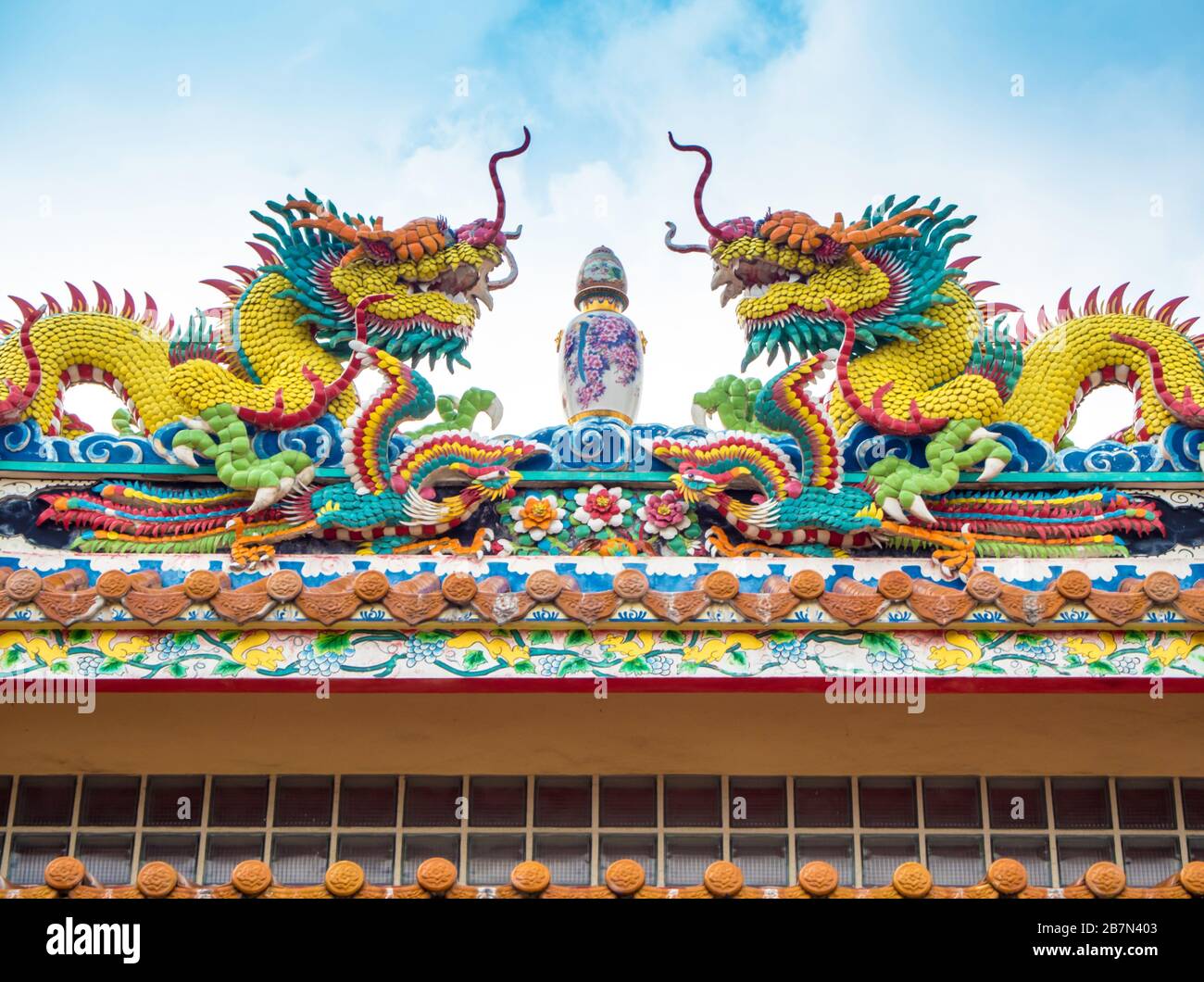 Colorful twin chinese dragon statues adorned the rooftops of pavilions ...