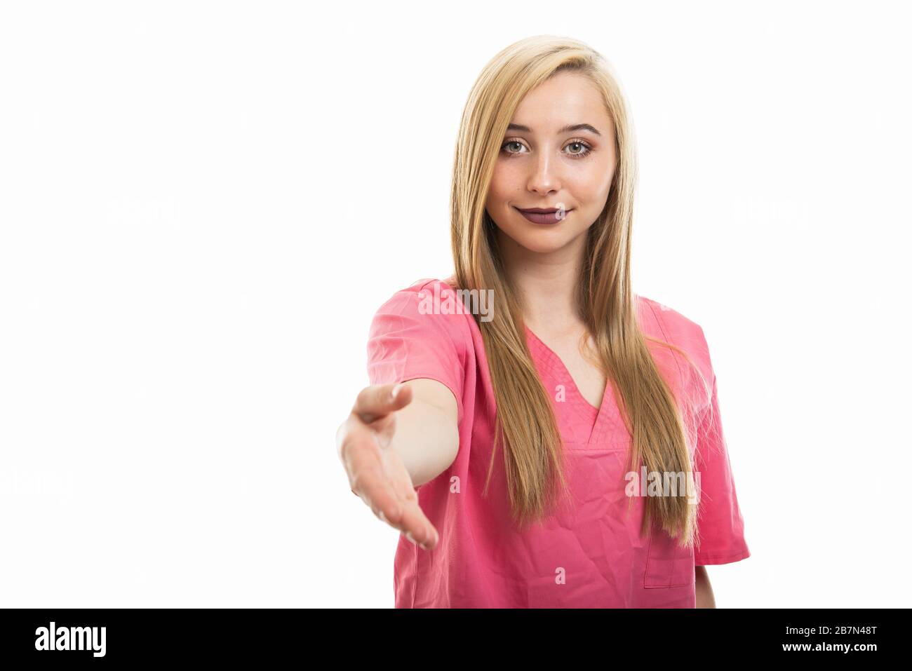 Portrait of young female nurse wearing scrubs offering hand shake ...