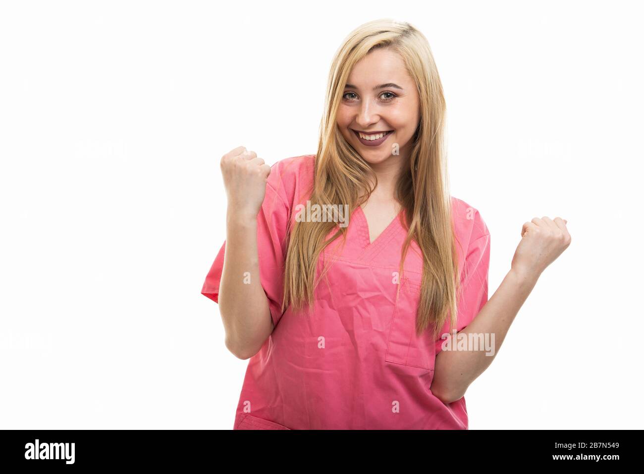 Portrait of female nurse wearing scrubs making happy gesture isolated ...