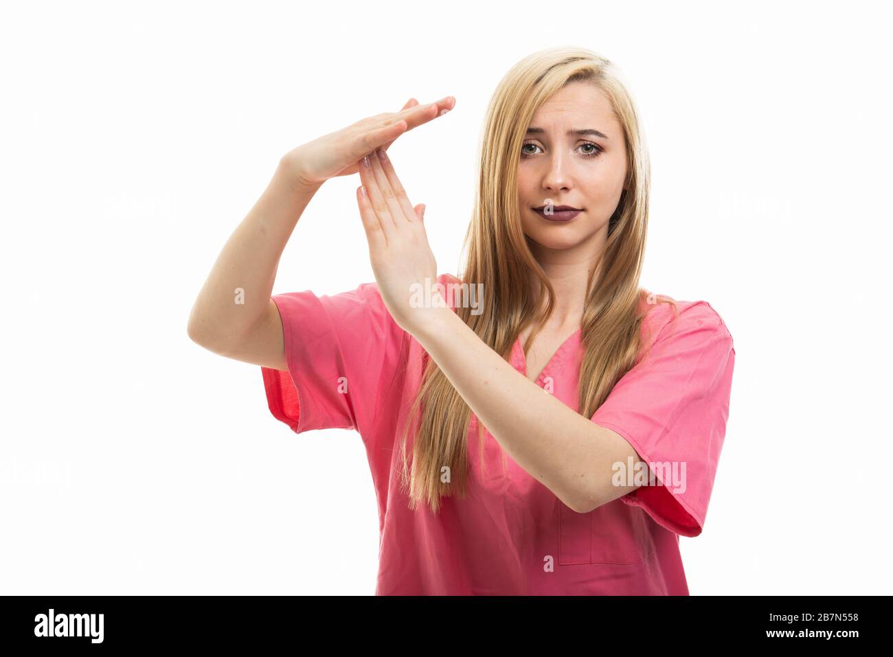 Portrait of female nurse wearing scrubs making time out gesture ...