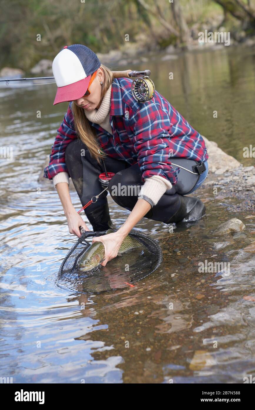 woman catching rainbow trout fly in river Stock Photo - Alamy