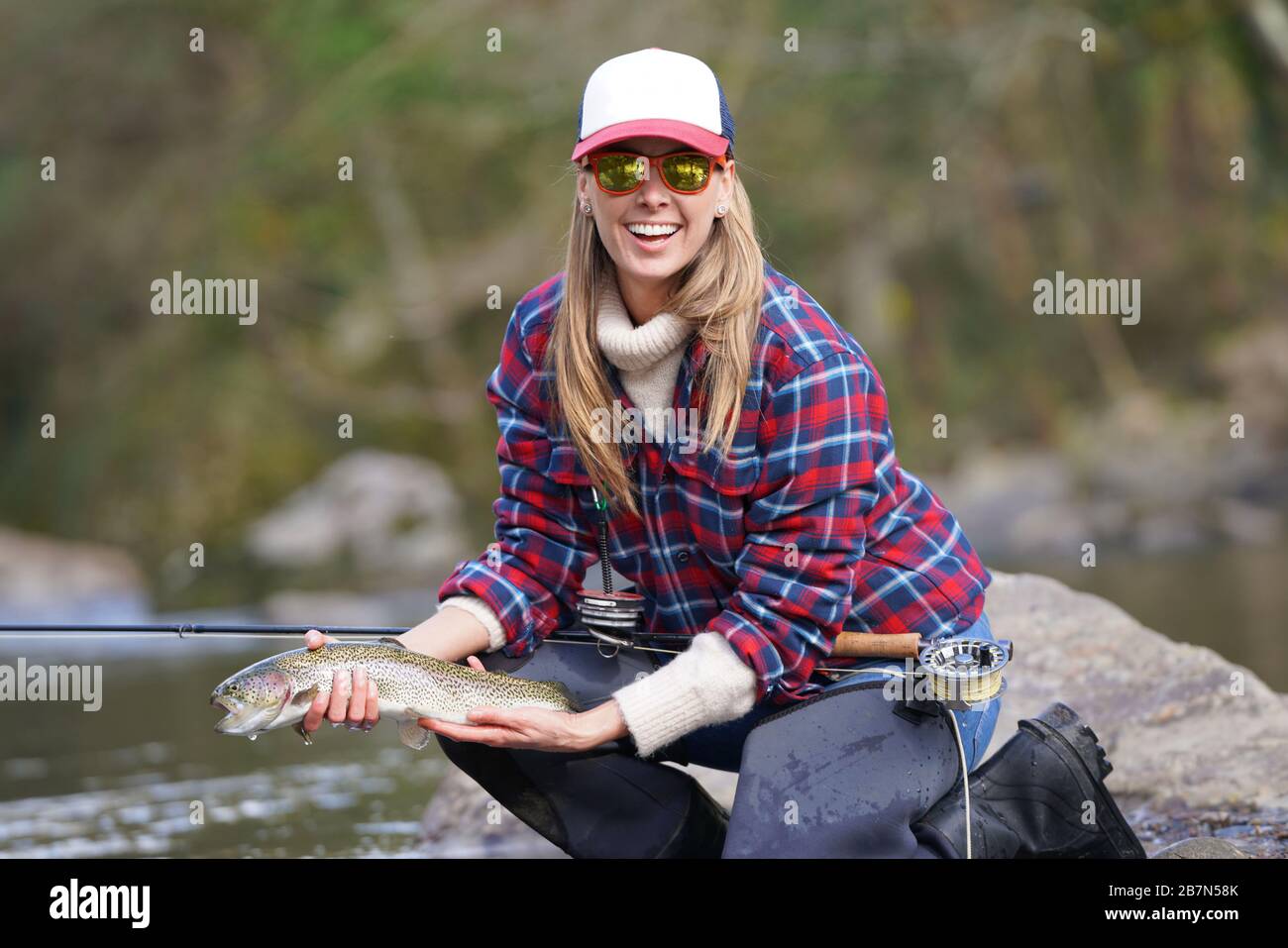 woman catching rainbow trout fly in river Stock Photo - Alamy
