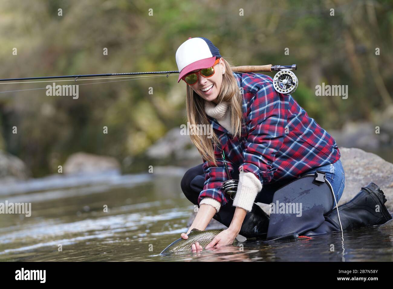 woman catching rainbow trout fly in river Stock Photo - Alamy