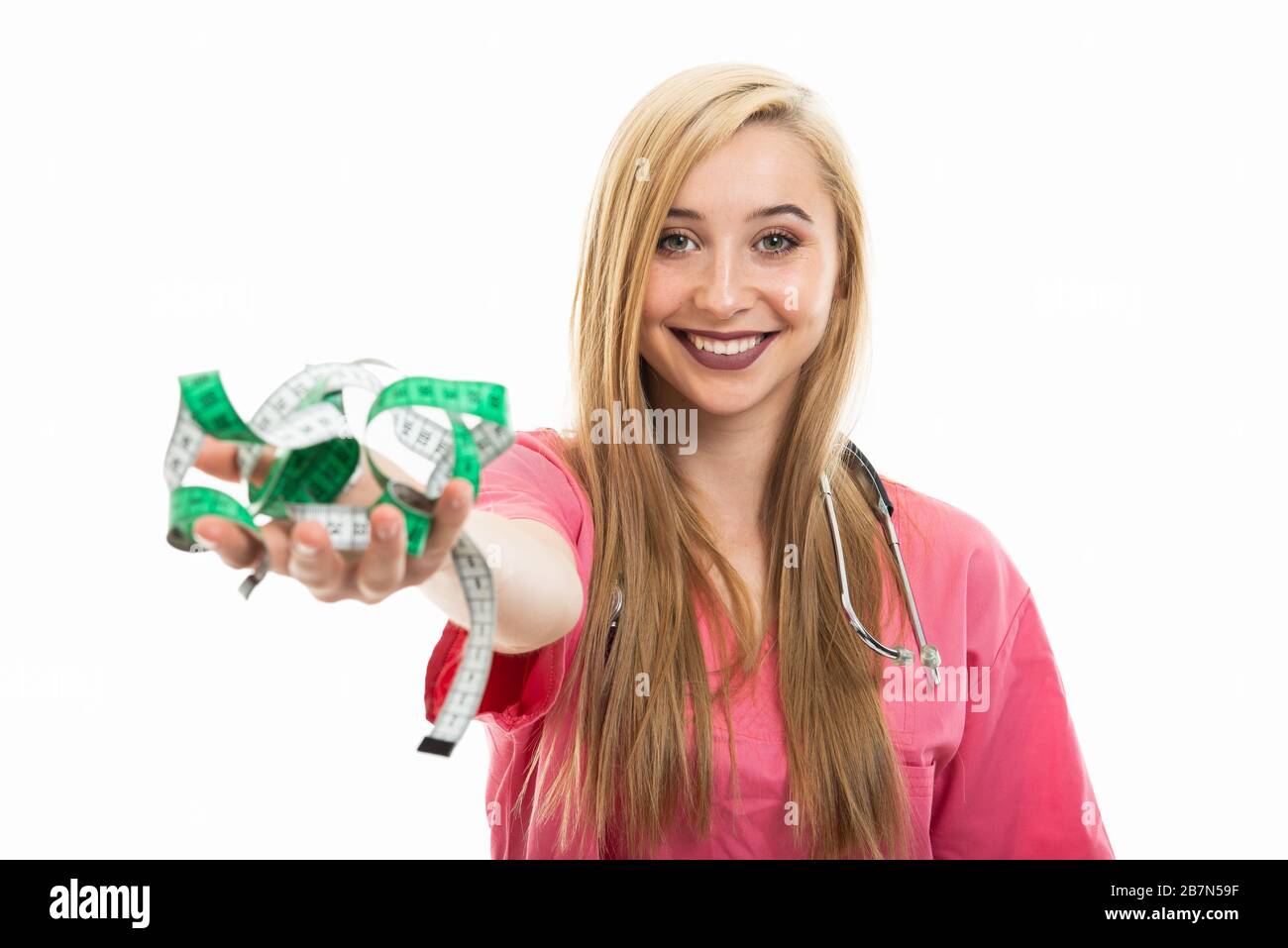 Portrait of female doctor wearing scrubs holding measuring tape ...