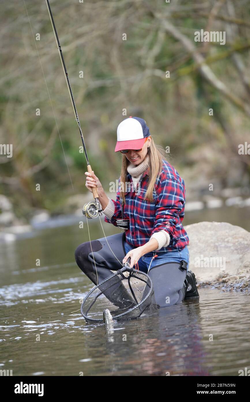 woman catching rainbow trout fly in river Stock Photo - Alamy