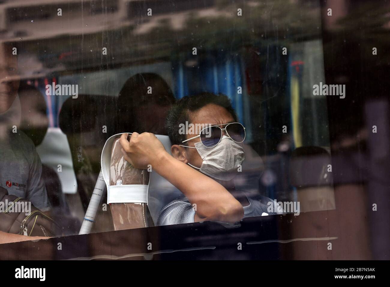 Manila, Philippines. 17th Mar, 2020. A passenger on a bus wears a face ...
