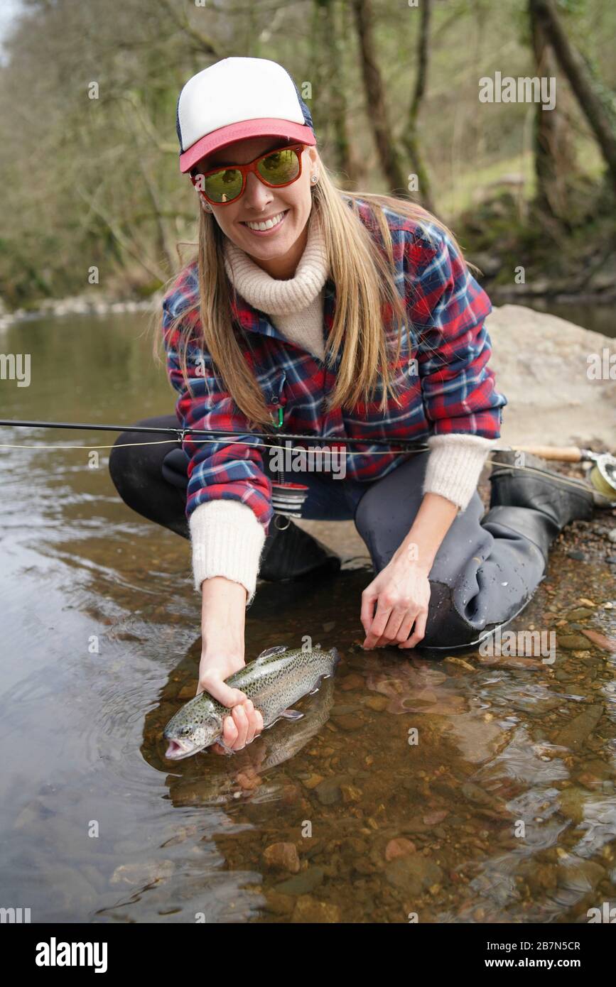 woman catching rainbow trout fly in river Stock Photo - Alamy