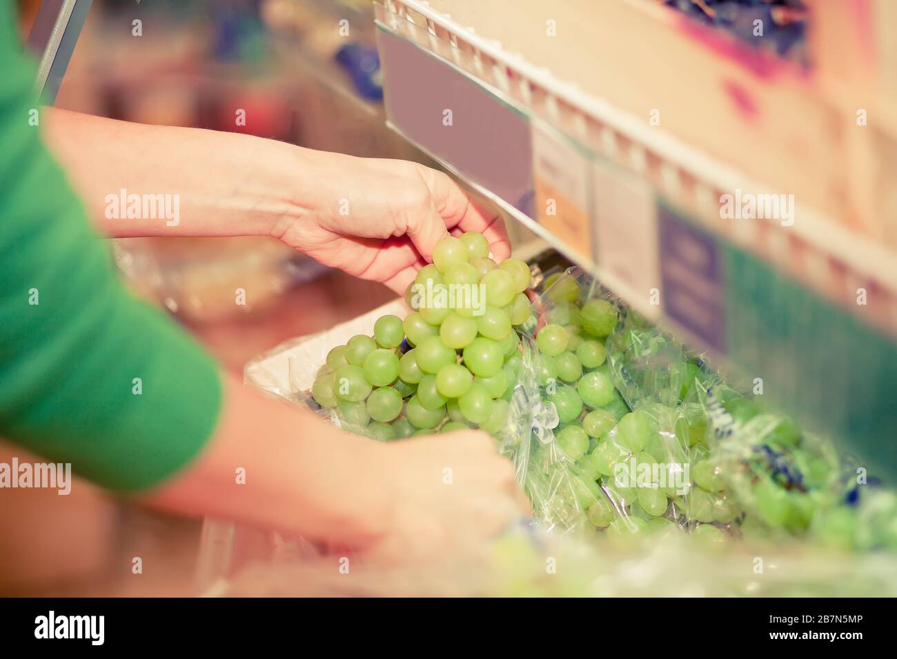 Young woman buying green grape in a supermarket Stock Photo - Alamy