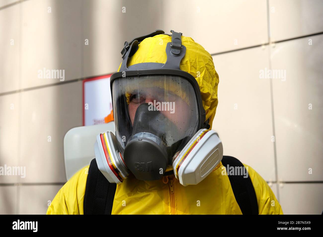 Paramedic wearing yellow protective costume and mask disinfecting ...