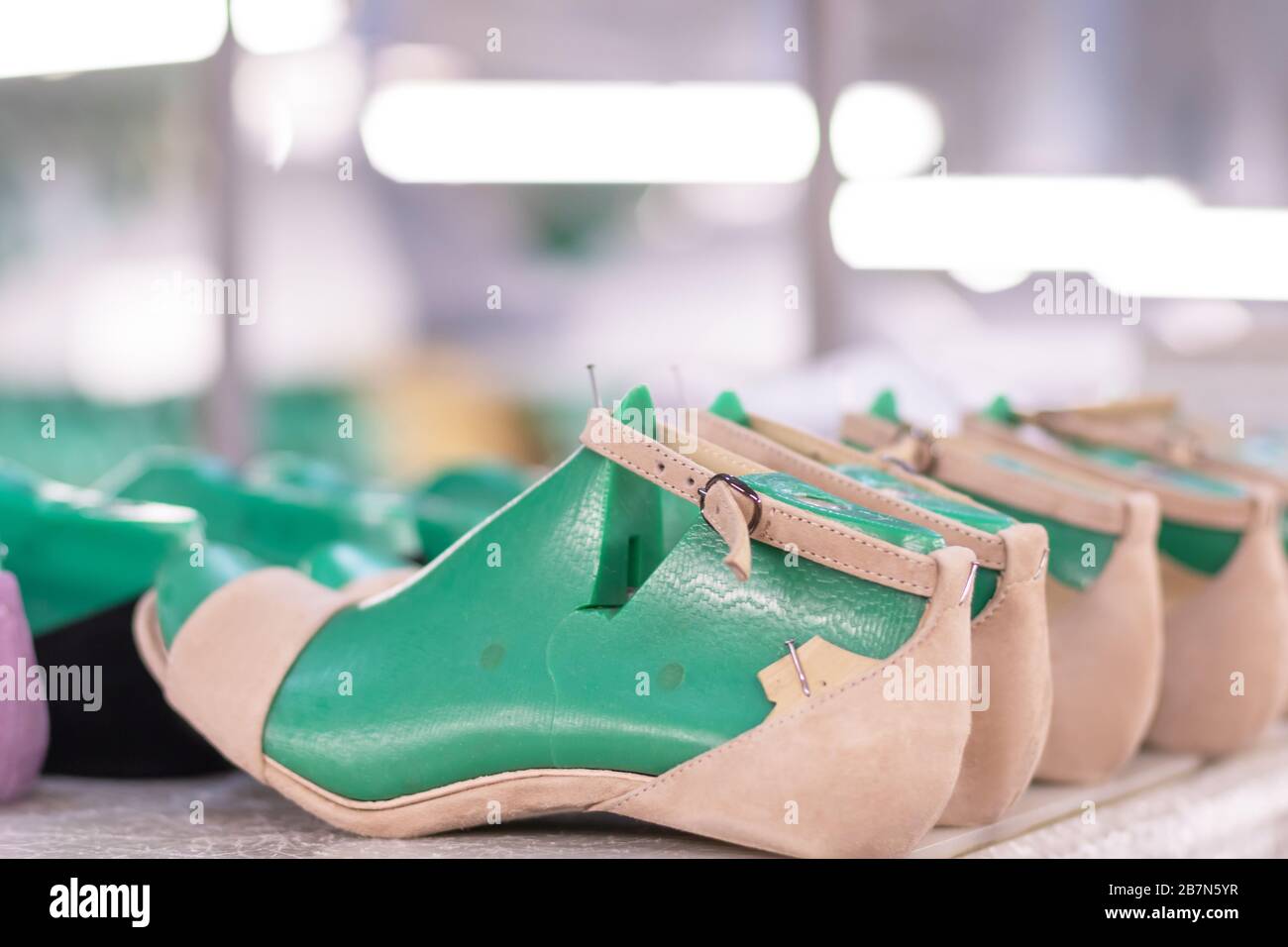 worker making white leather shoe on production line conveyor in ...