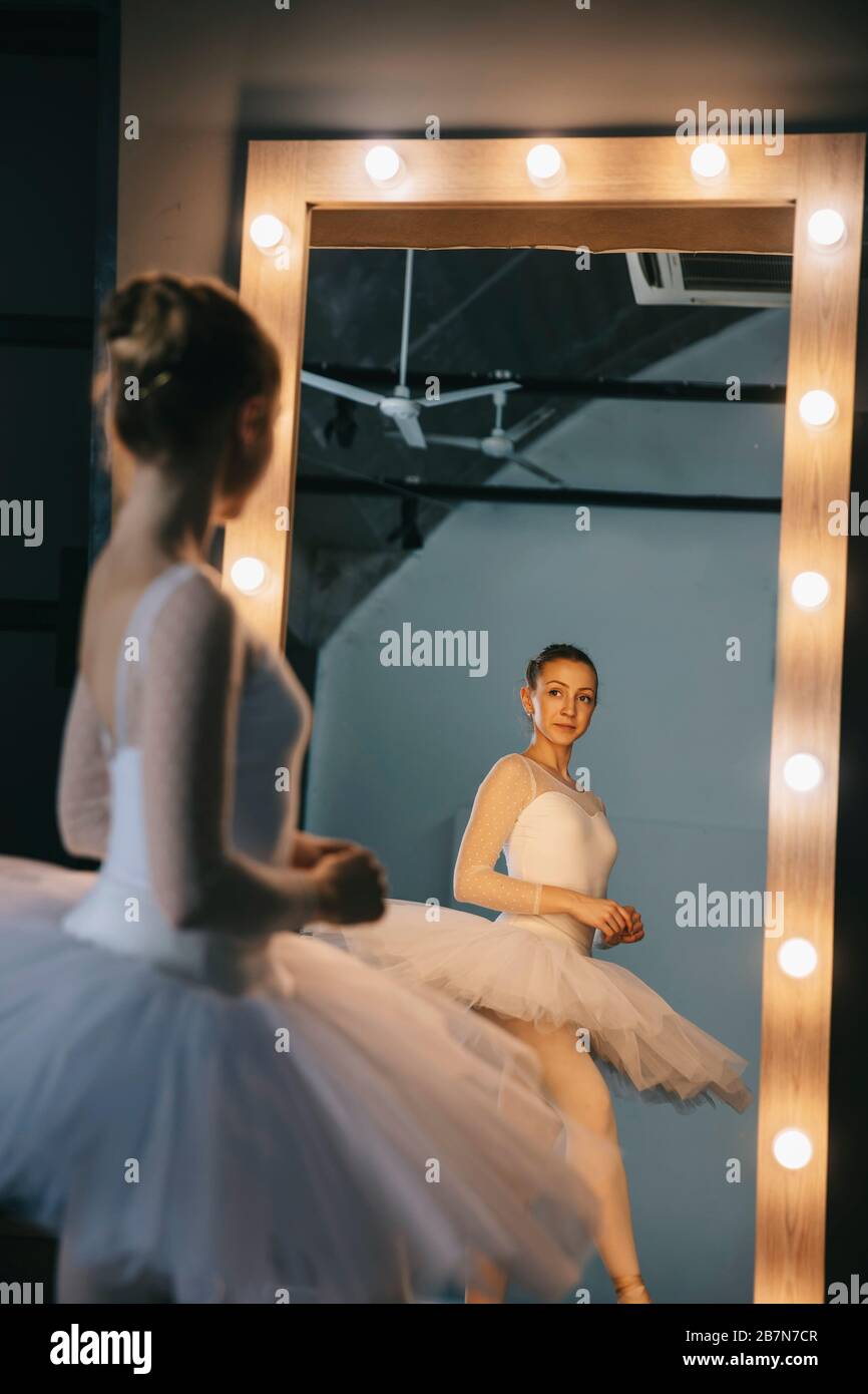 Young ballerina in white dress with a perfect body is dancing in the ...