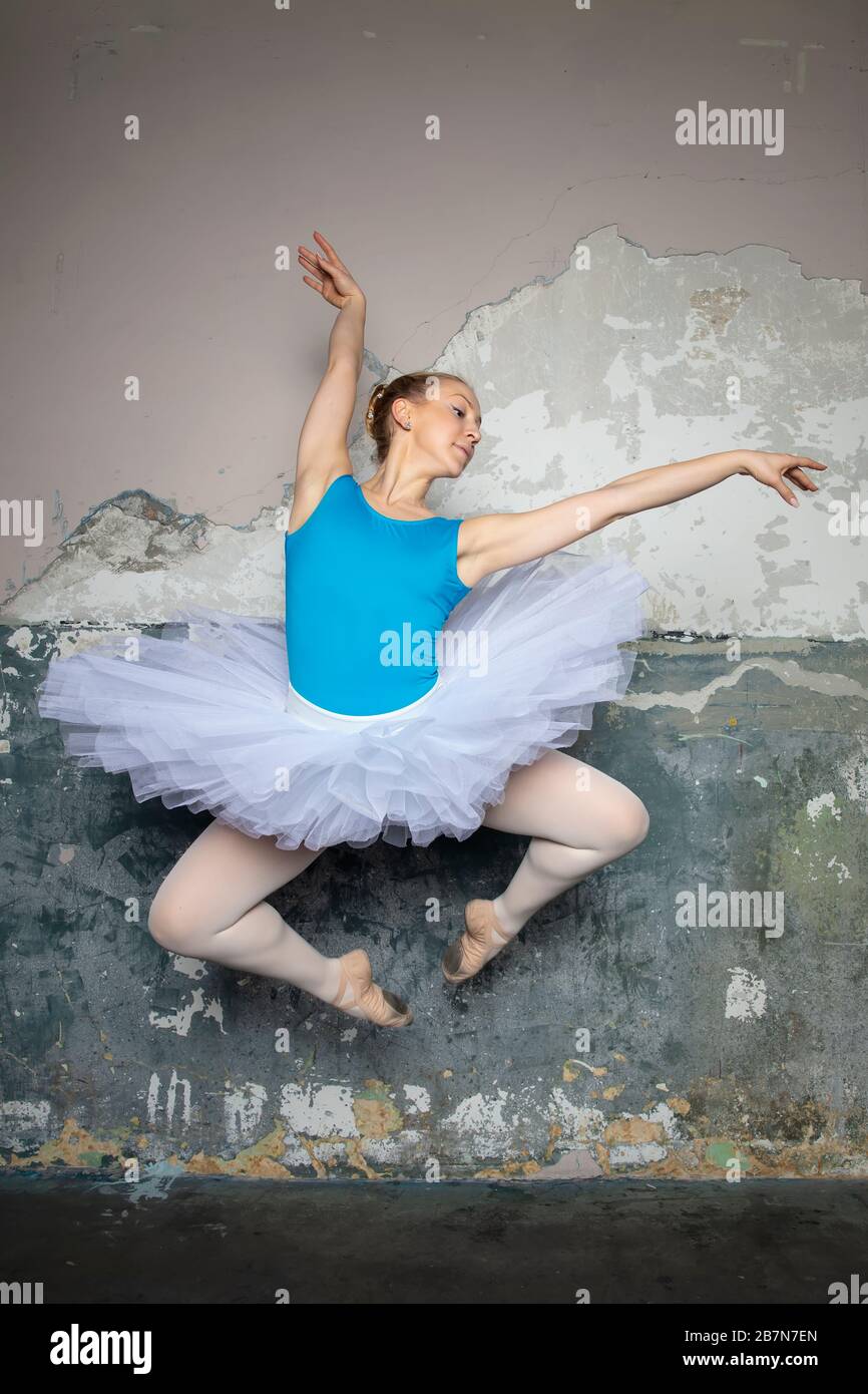 Ballerina dancer performing a jump in front of grunge wall Stock Photo ...