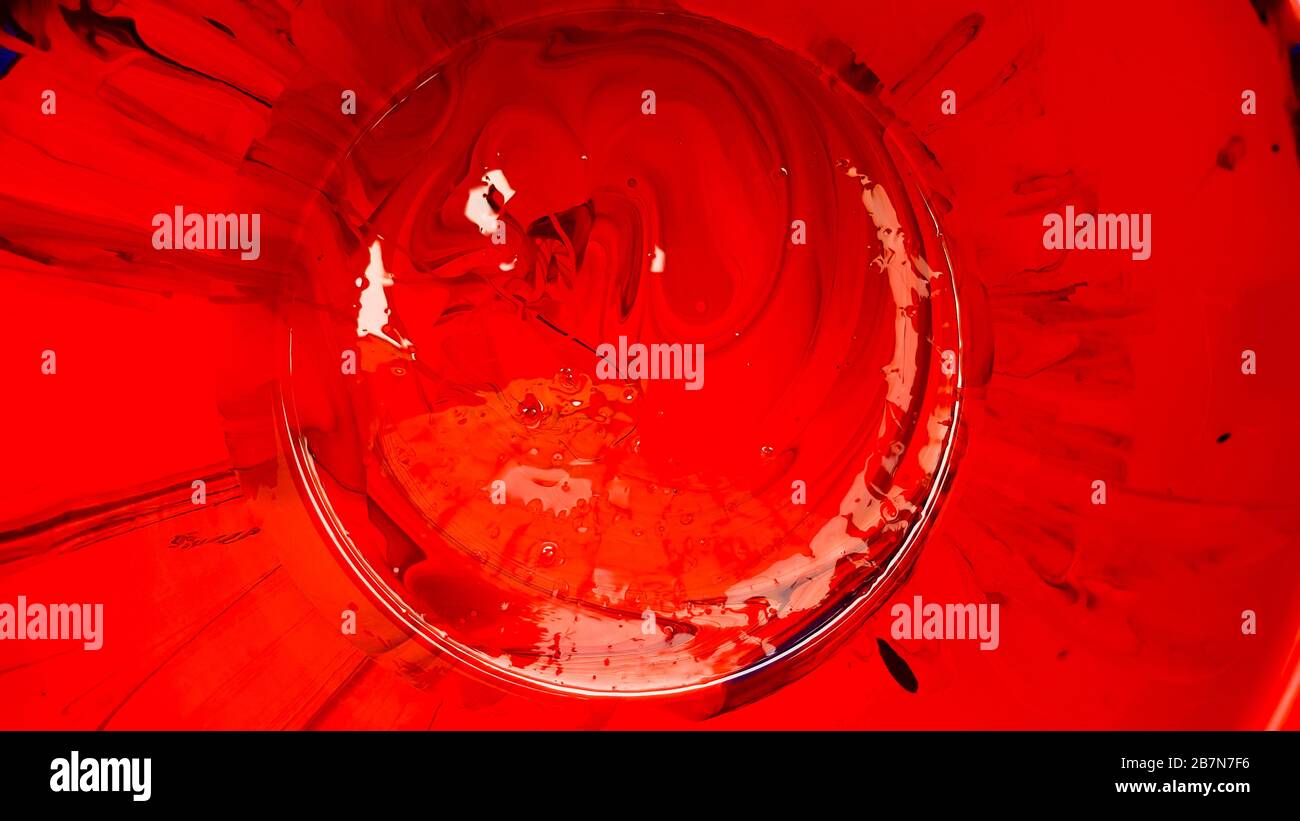 Abstract background of spilled red paint with buckets on a black ...