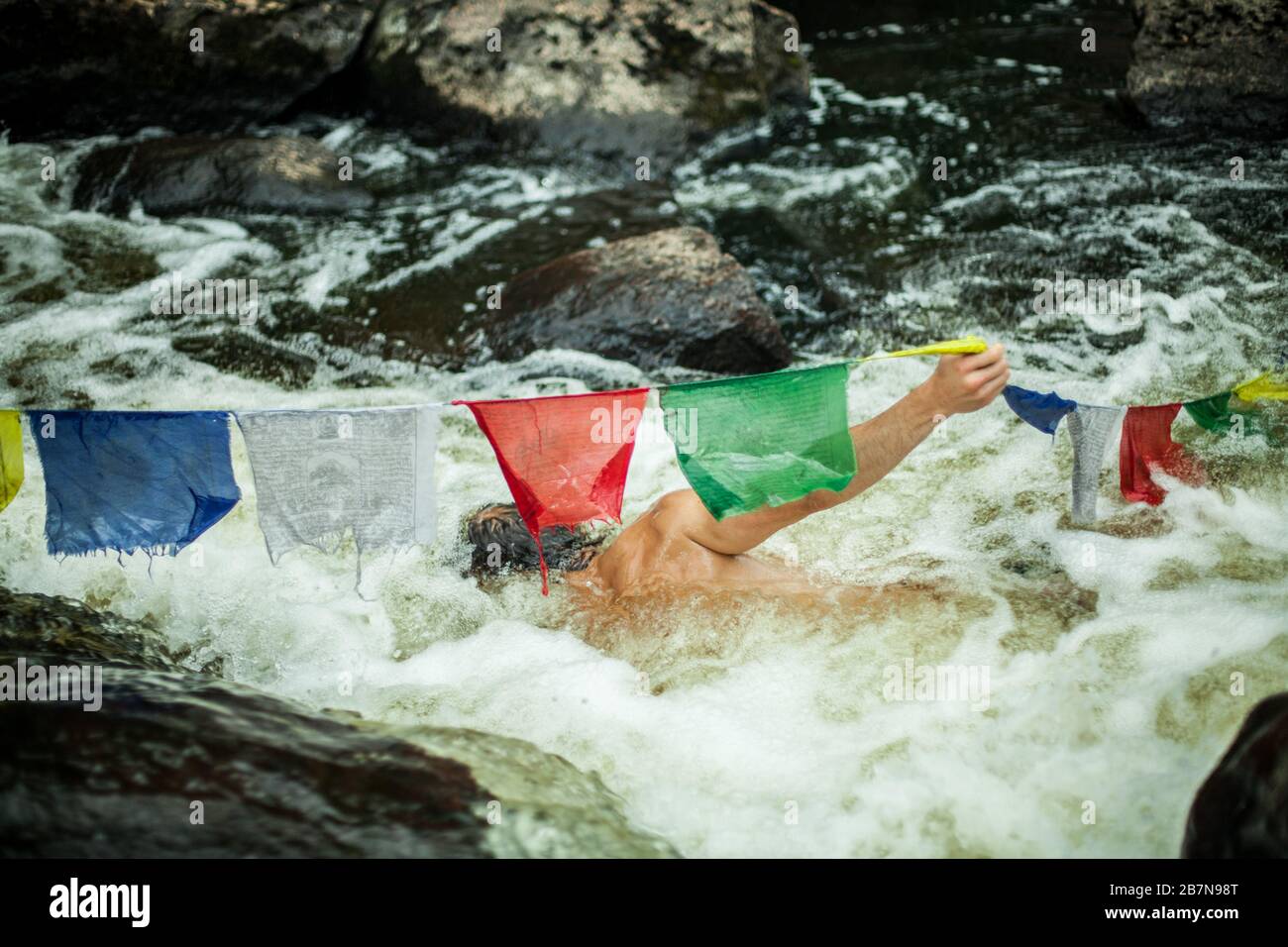 A close up shot as a spiritual caucasian man swims in a fast flowing ...