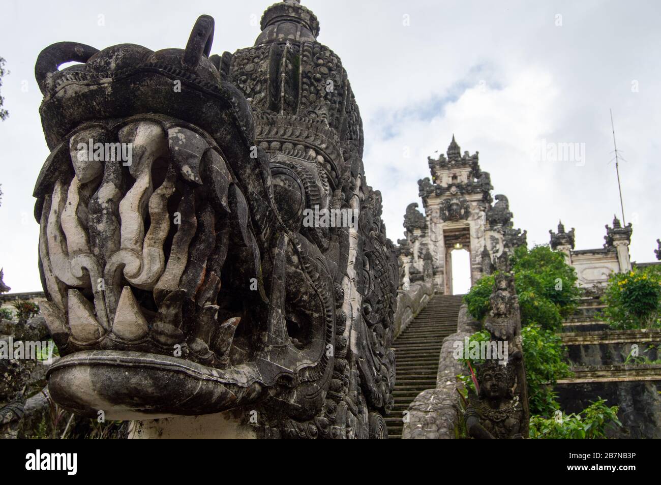 Monster face with fangs in front of the entrance of the Pura Penataran ...