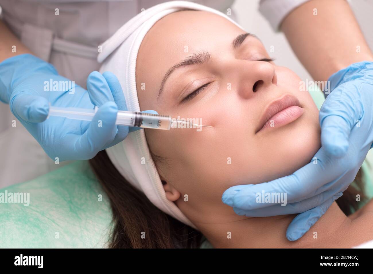 injection into the skin of the face of a young woman, close-up ...