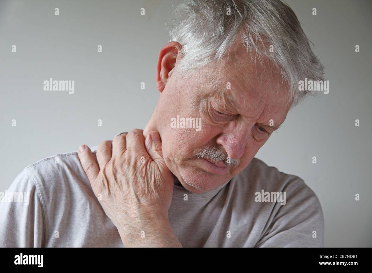 A senior man with his hand on his neck with copy space Stock Photo - Alamy