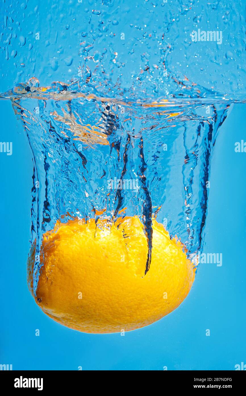 Fresh lemon drops in water with a splash on a blue background Stock ...