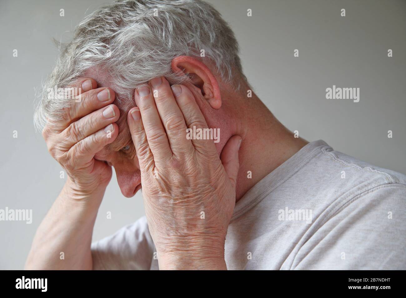 Senior man with his hands almost covering his face Stock Photo - Alamy