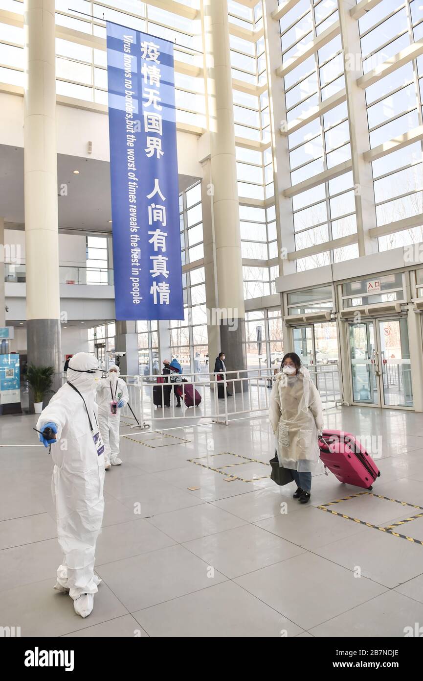 Beijing, China. 17th Mar 2020. Staff members guide inbound passengers ...