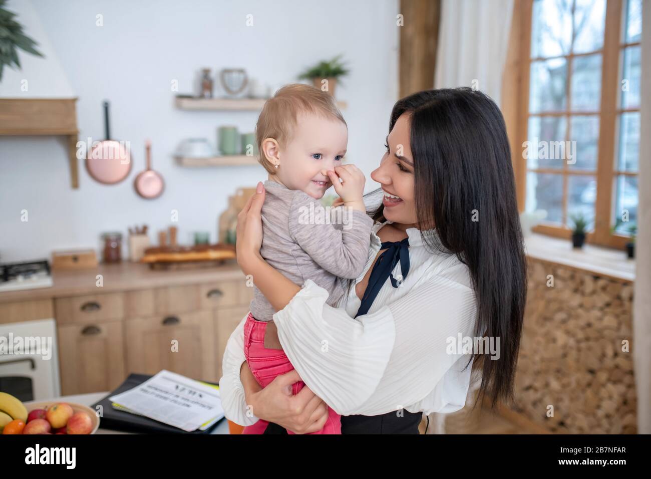 Young mom holding kid, both smiling happily Stock Photo - Alamy