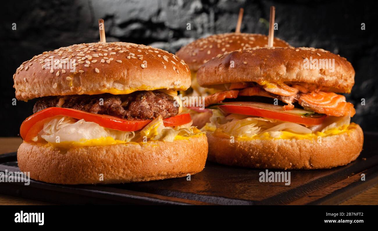 Menu of different burgers on one board. Side view of a fish burger ...