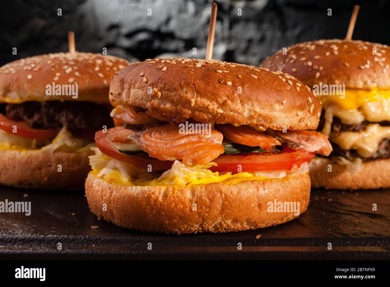 Menu of different burgers on one board. Side view of a fish burger ...