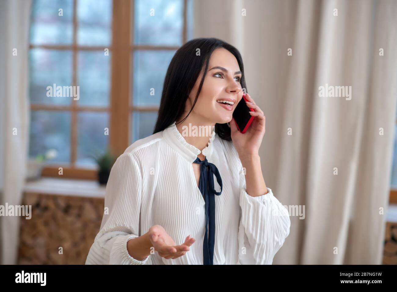 Young woman talking on phone, smiling happily Stock Photo - Alamy