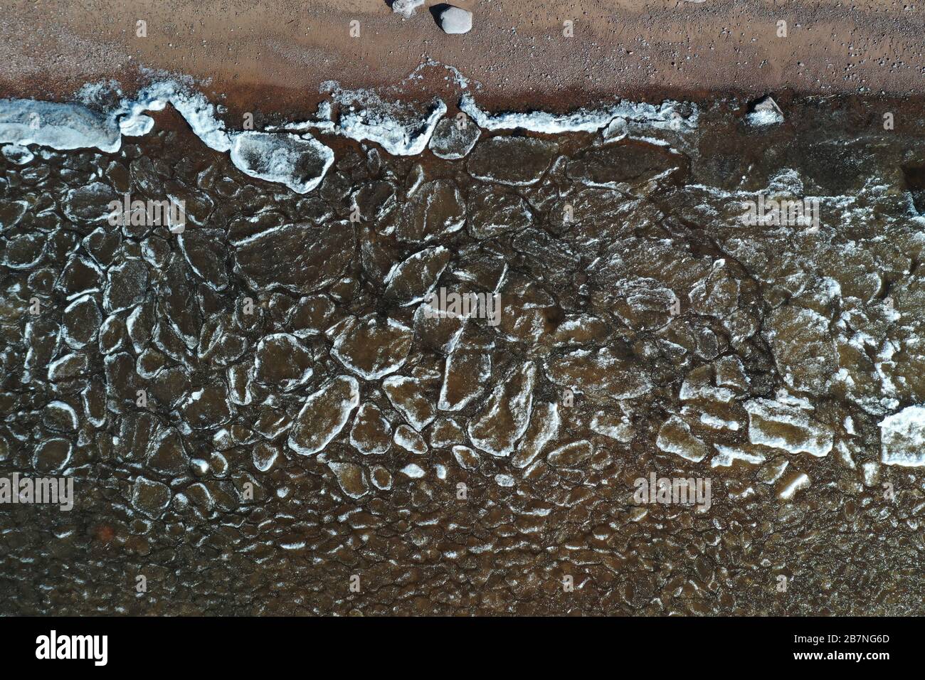 Pieces of ice float on waves, Ice plaques, sandy coast, stones, spring ...