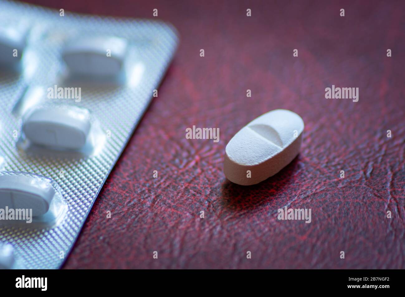 White single pill lies on the dark background Stock Photo - Alamy