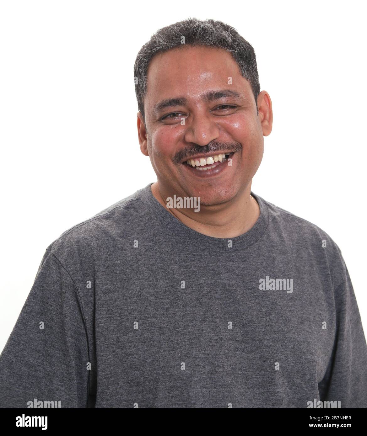 A smiling Indian man in a studio against a white background looking to ...