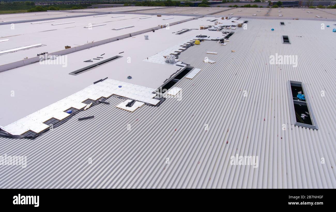 High angle shot of construction on the roof of a warehouse Stock Photo ...