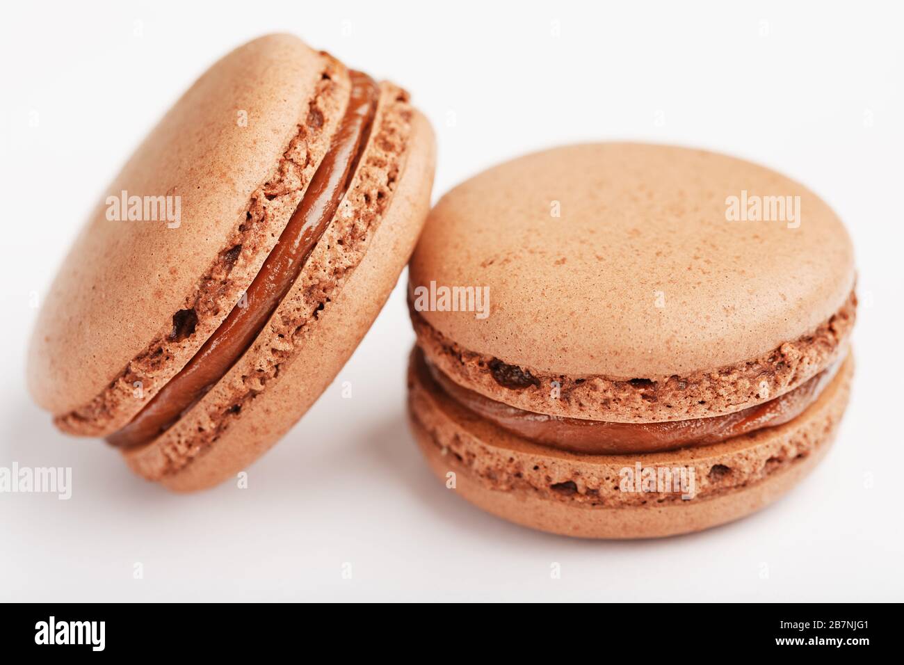Chocolate macaroni cookies on a white background with brown filling ...